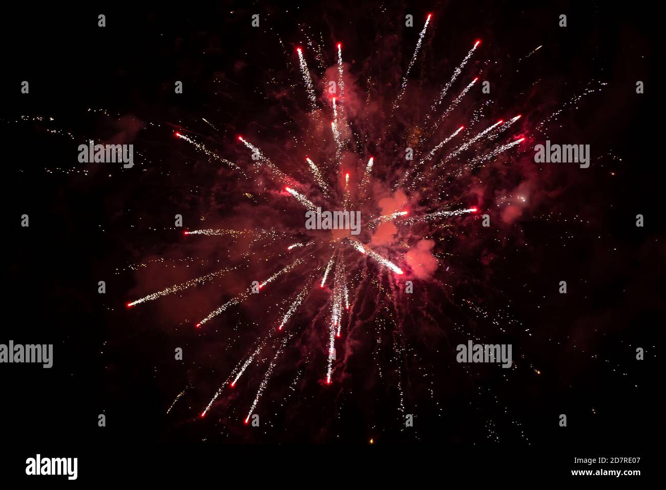 Red explosion of fireworks with smoke and bokeh on a black background ...