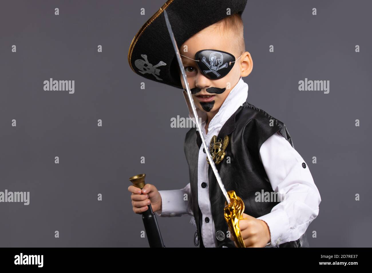 A kindergarten boy in a pirate captain costume with a painted face ...