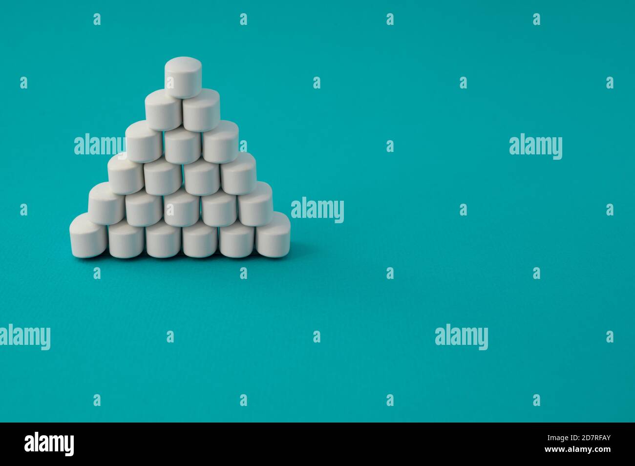 pharmacy medical concept of pyramid of white pills tablets on cyan ...