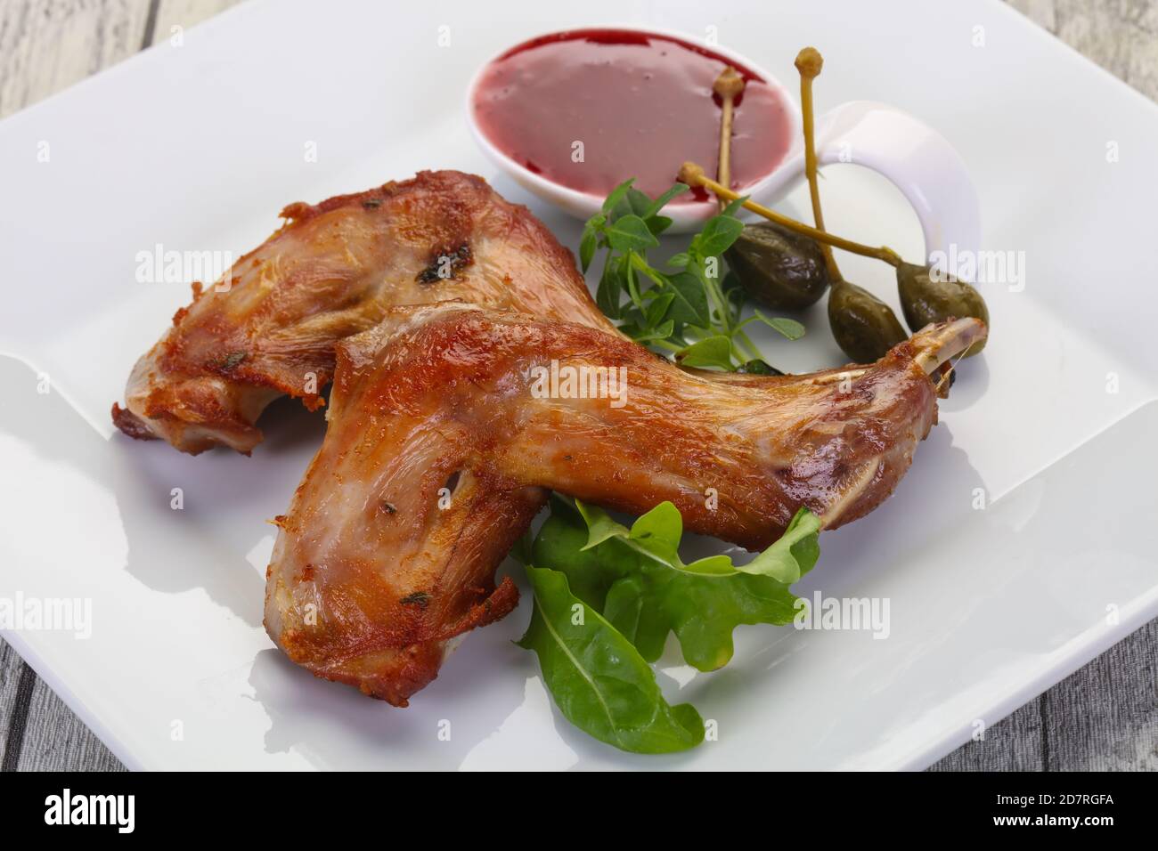 Roasted rabbit legs with cowberry sauce Stock Photo - Alamy
