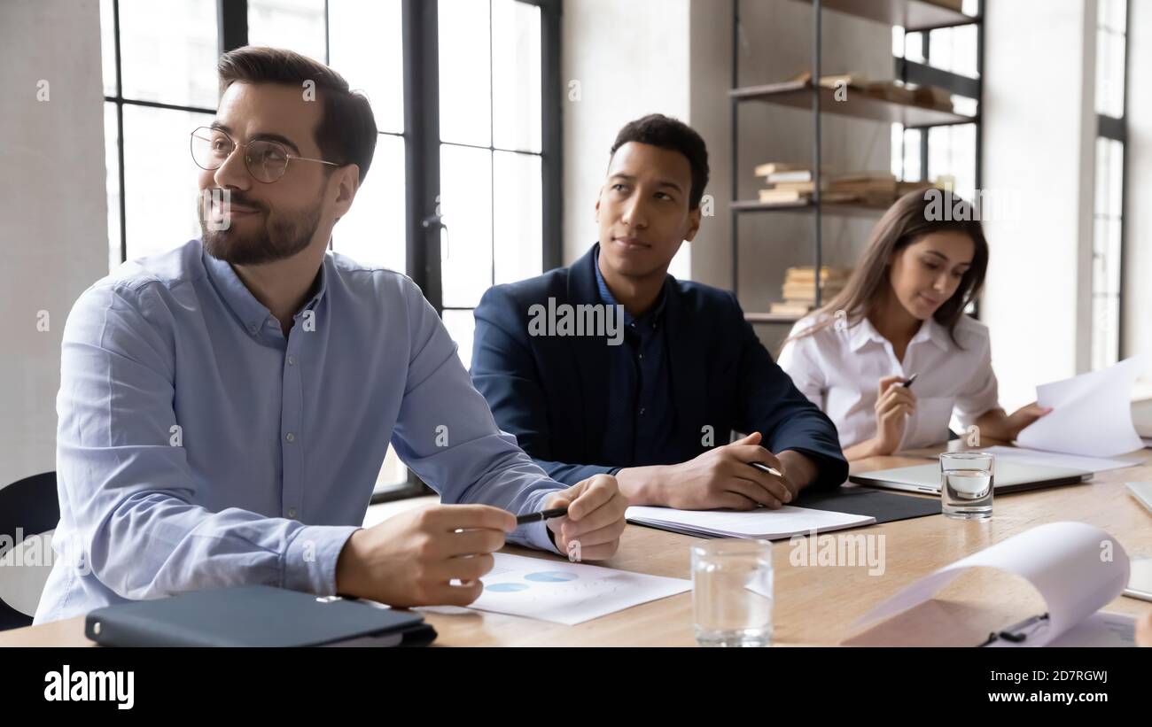 Focused diverse employees listen to coach talking at meeting Stock ...