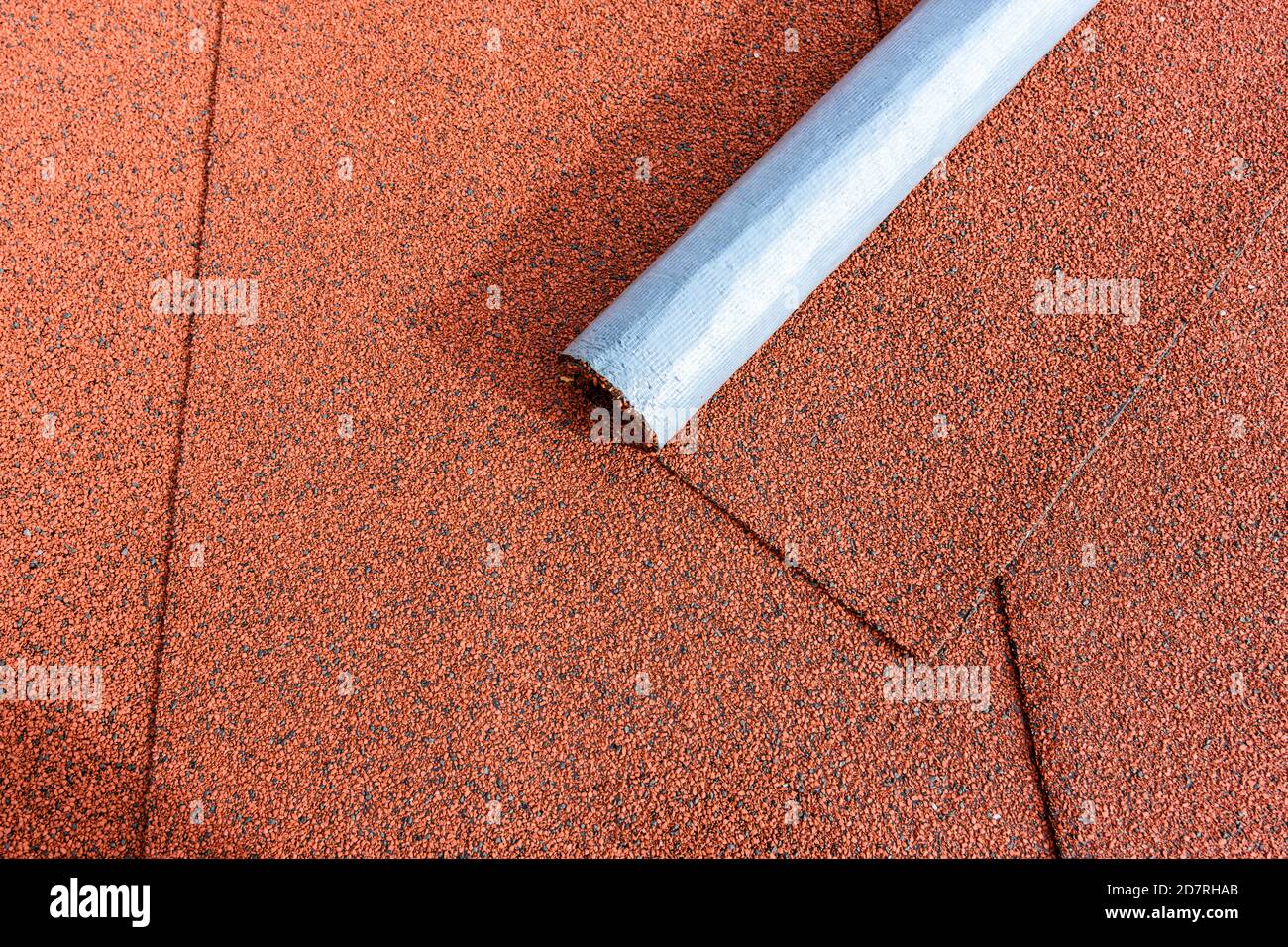 There is a roll of red bituminous shingles on the tiled roof Stock ...