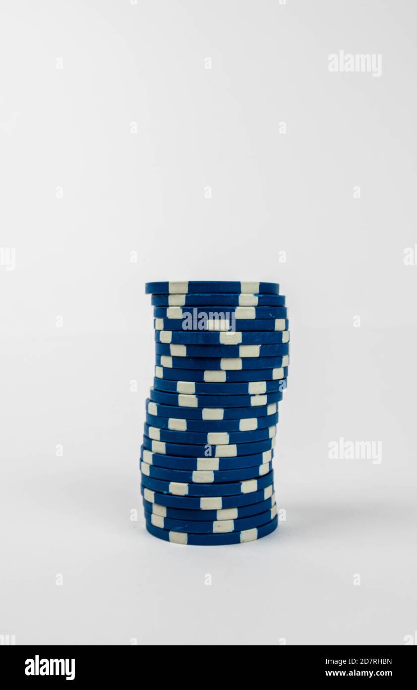 Vertical shot of stacked blue poker chips over white background Stock ...