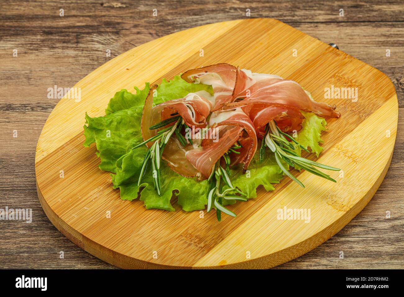 Sliced pork Jamon meat with rosemary Stock Photo - Alamy