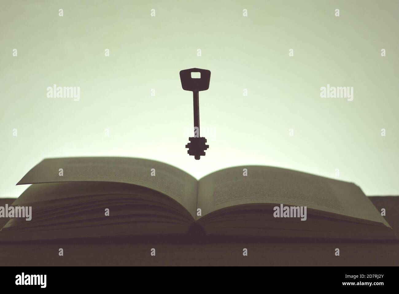 Open book and a flying key Stock Photo - Alamy