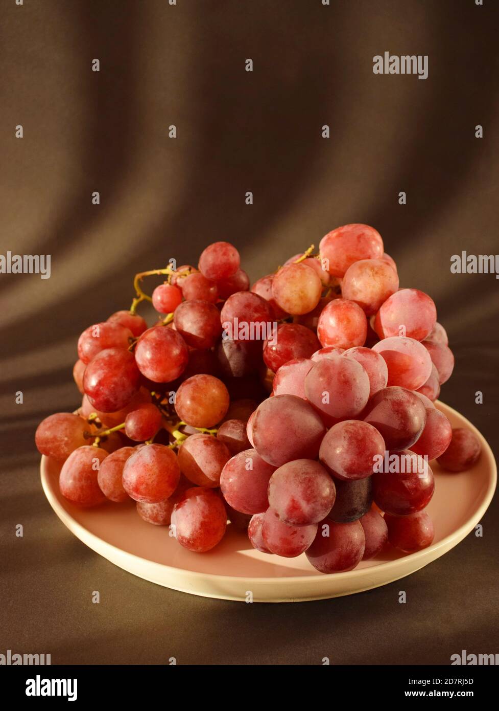 Fresh natural organic red grapes on a black background with shadows ...