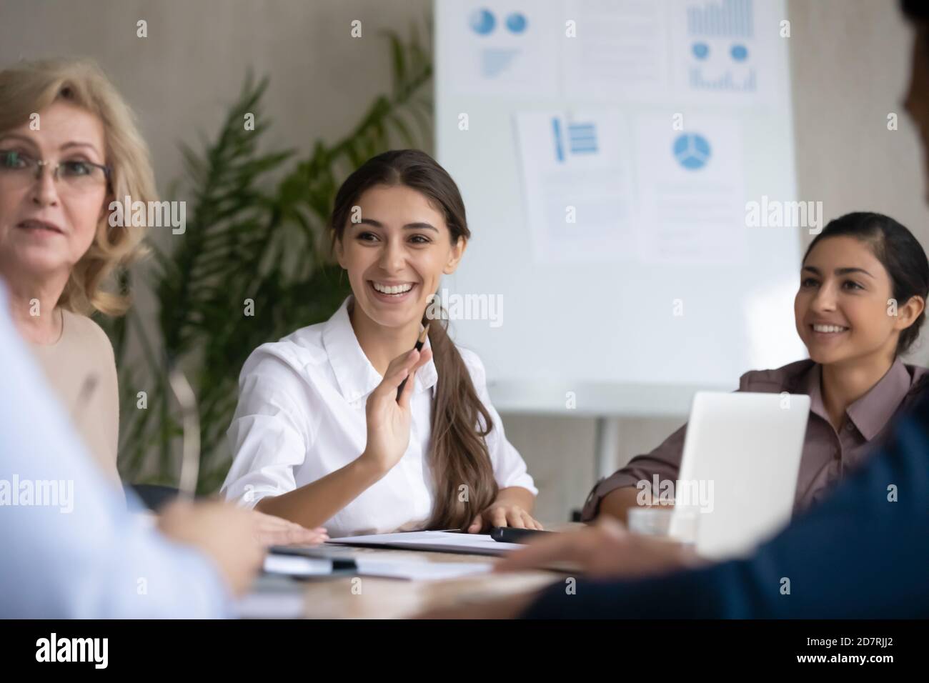 Smiling multiracial female colleagues brainstorm at office briefing ...
