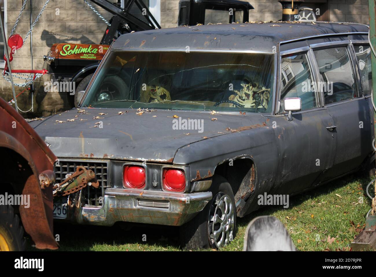 Halloween decoration of an old broken down hearse being driven by a ...