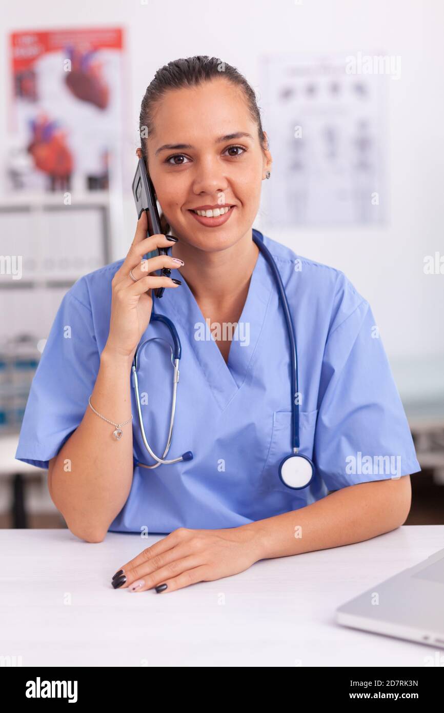 Medical staff talking with patient on phone from hospital office about ...
