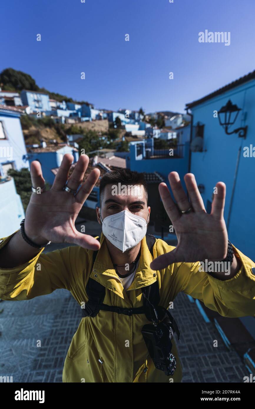 Vertical shot of a young man posing wearing a sanitary mask - concept ...