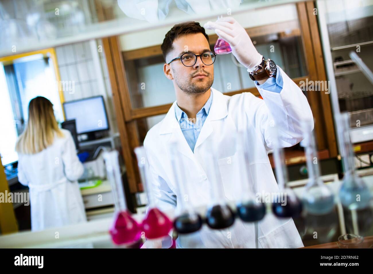 Young researcher checking test tubes in the laboratory Stock Photo - Alamy