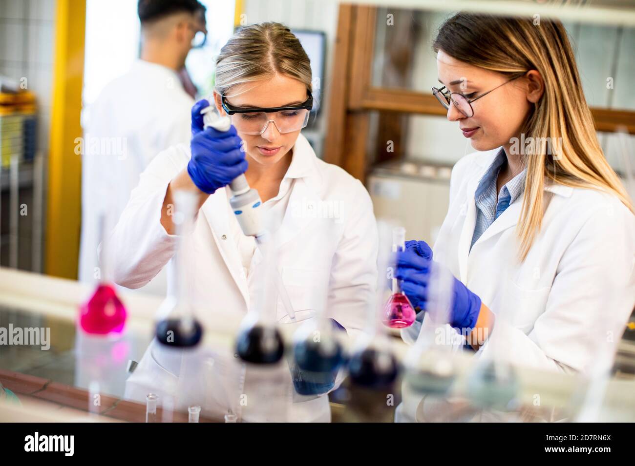 Cute female researchers in white lab coat working in the laboratory ...