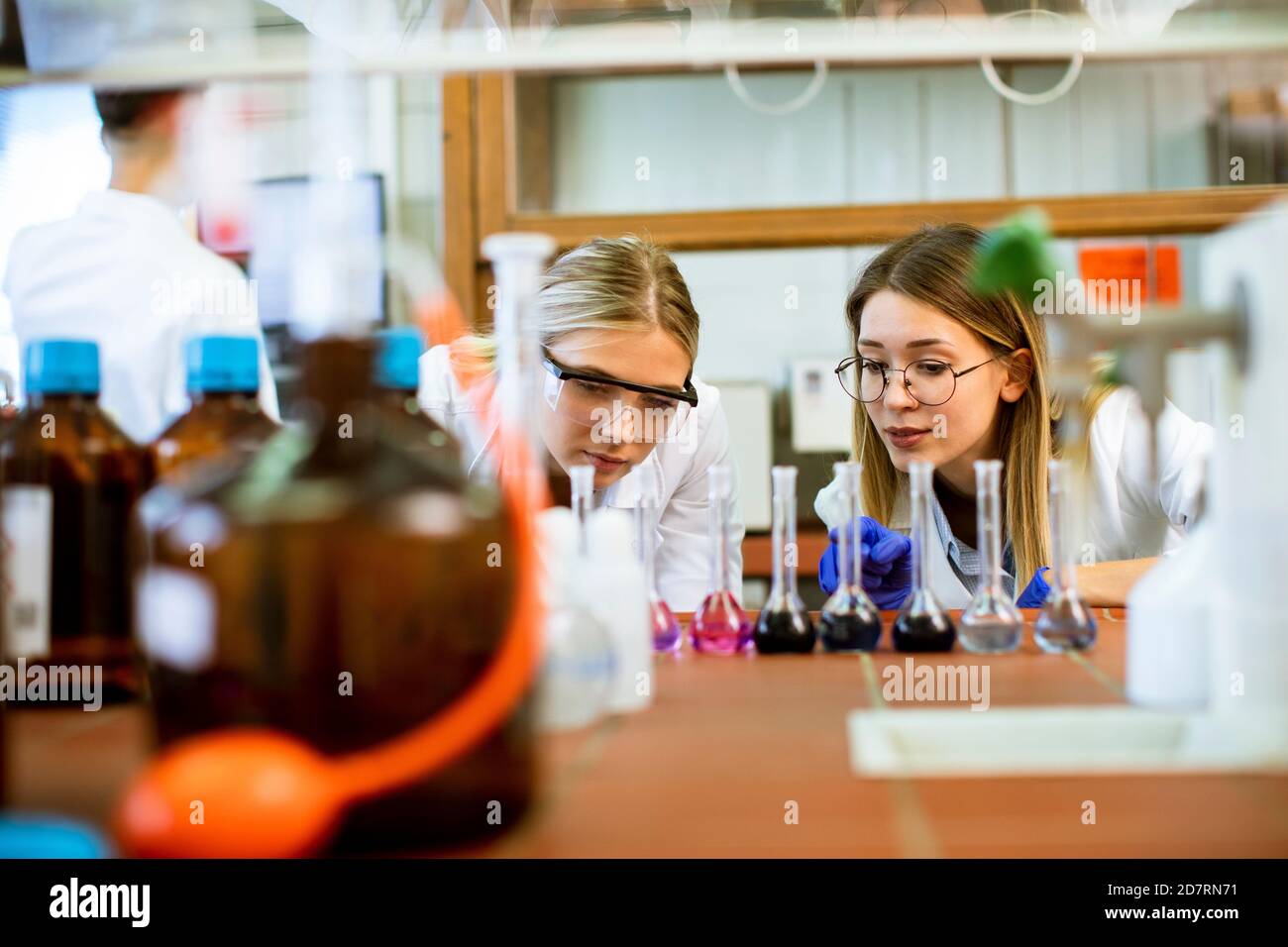 Cute female researchers in white lab coat working in the laboratory ...