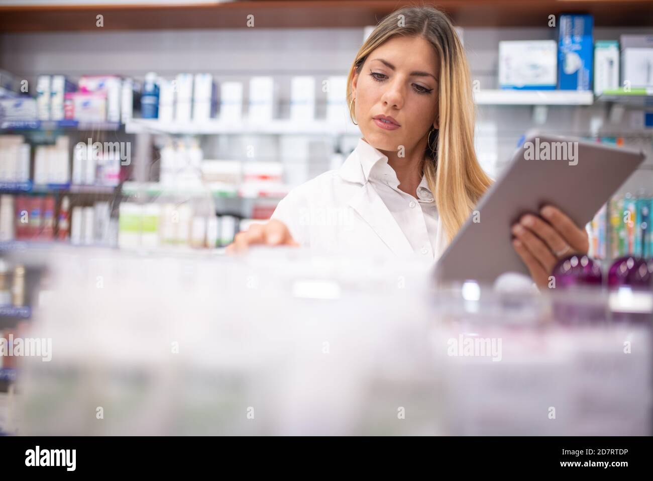 Young female pharmacist checking the inventory in a pharmacy Stock ...