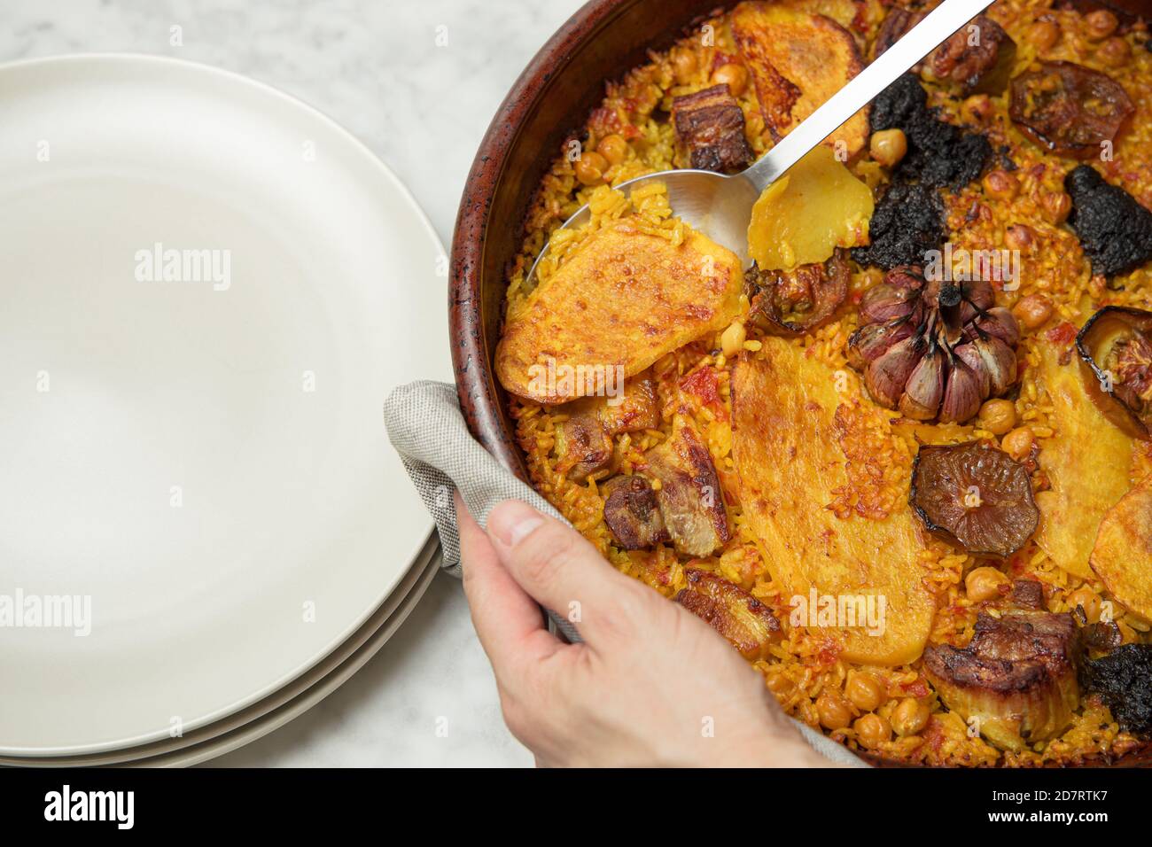 Delicious oven-baked rice on a marble table, ready to serve. Valencia ...
