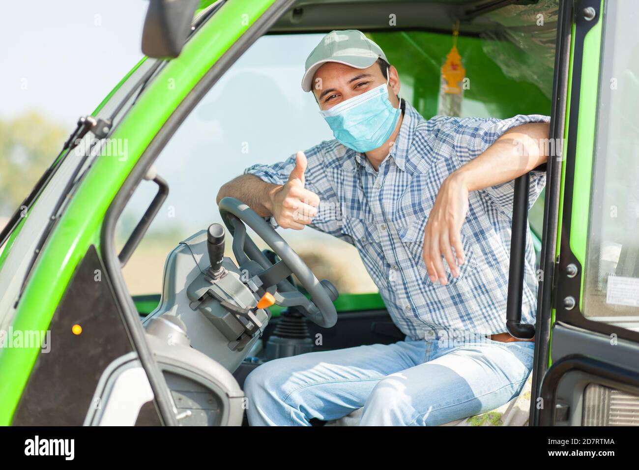 Farmer driving tractor in corn field Stock Photo - Alamy