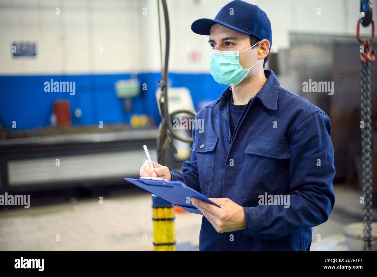 Industrial worker writing on a document in a factory Stock Photo - Alamy