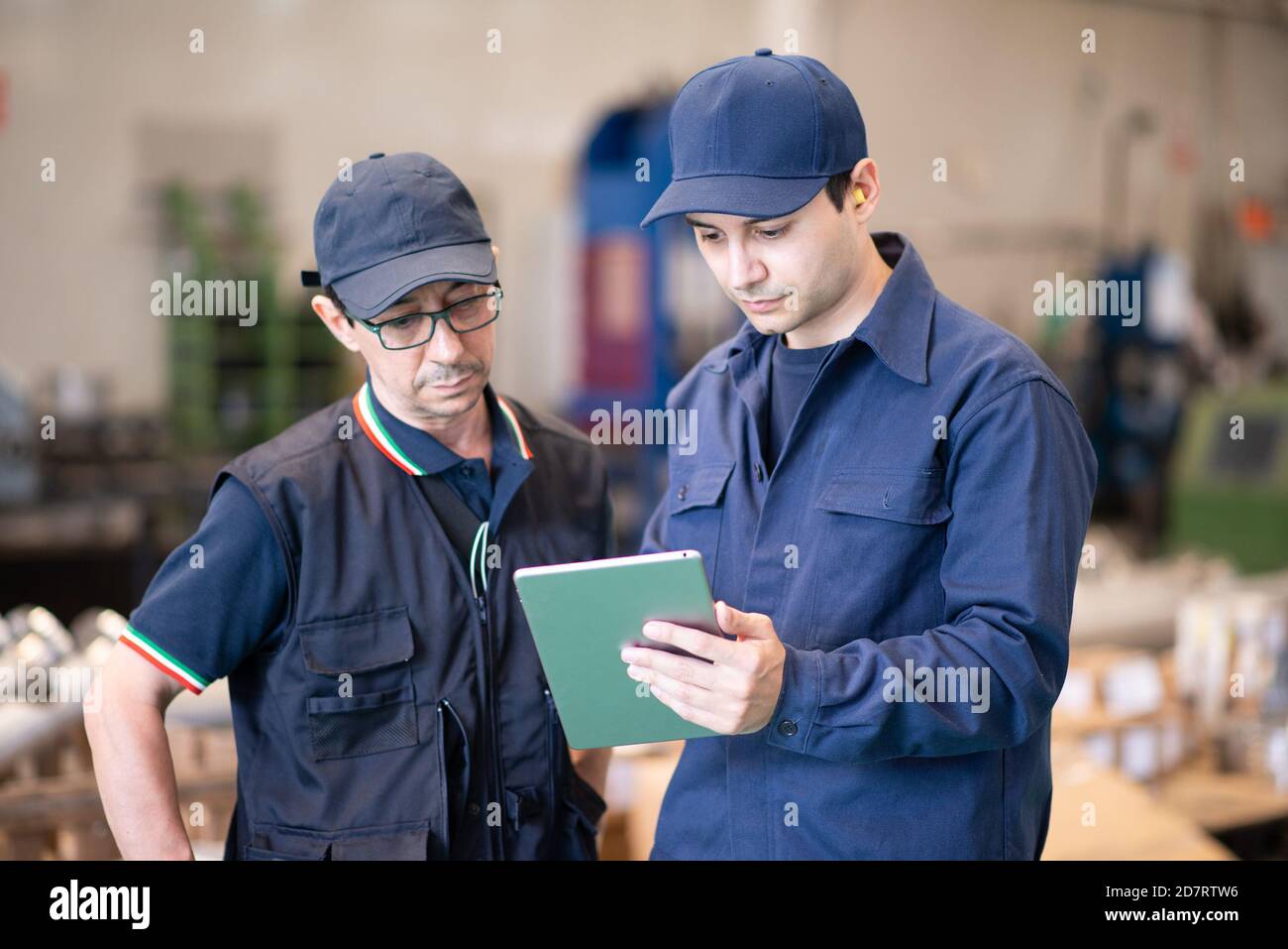Two workers using a tablet in a modern factory Stock Photo - Alamy