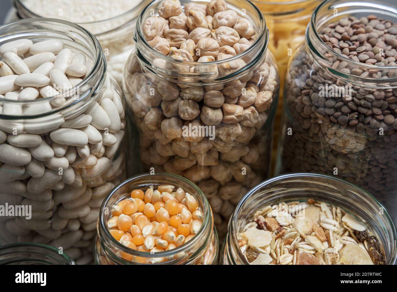 Set of glass jars with various ingredients placed on a table. Zero ...