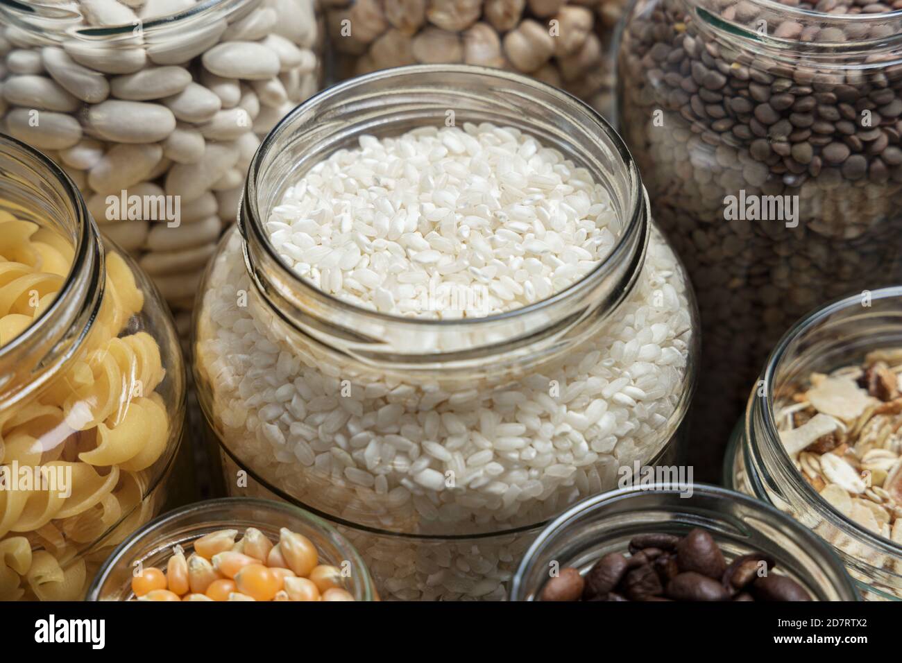 Set of glass jars with various ingredients placed on a table. Zero ...