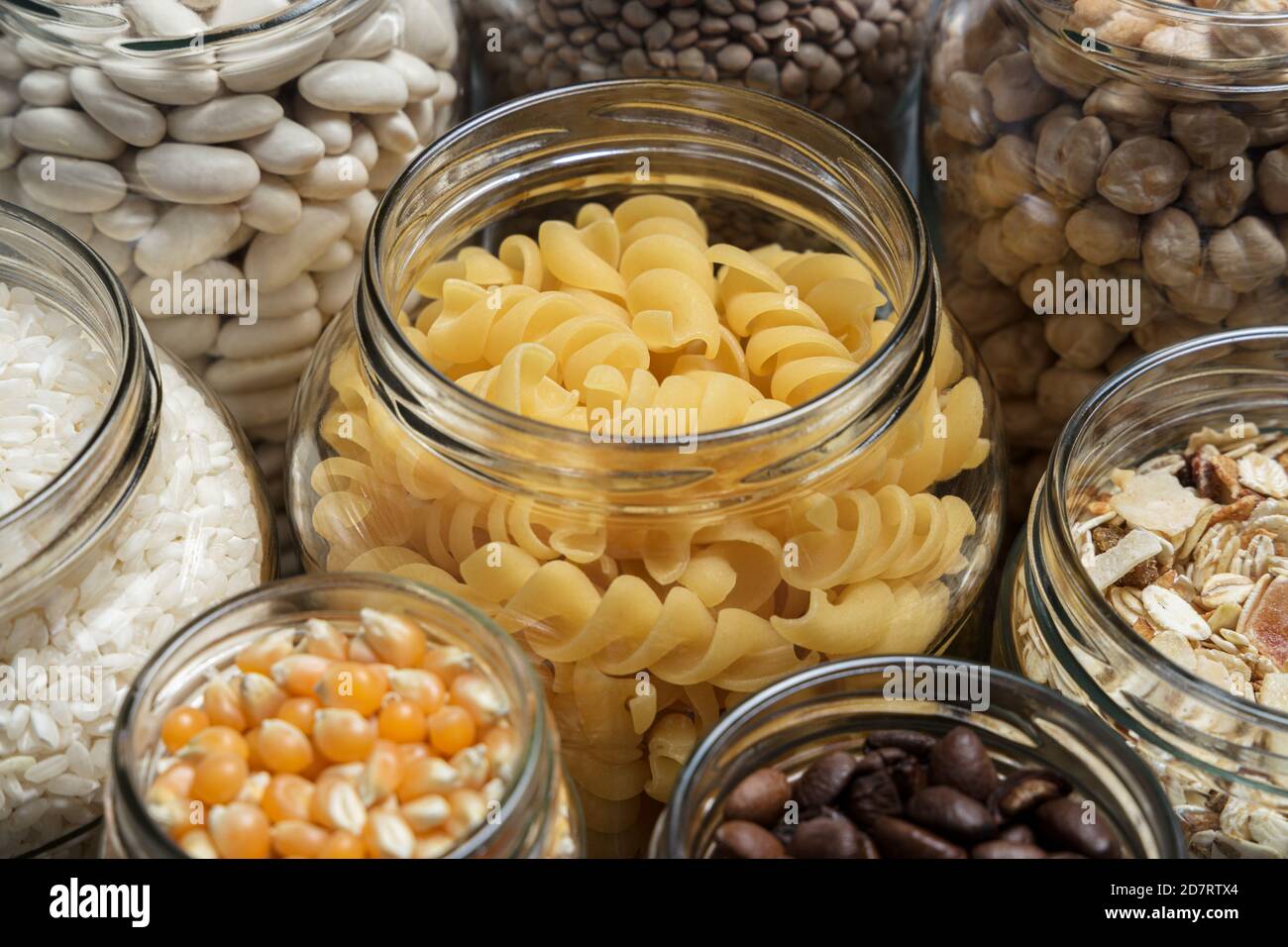 Set of glass jars with various ingredients placed on a table. Zero ...