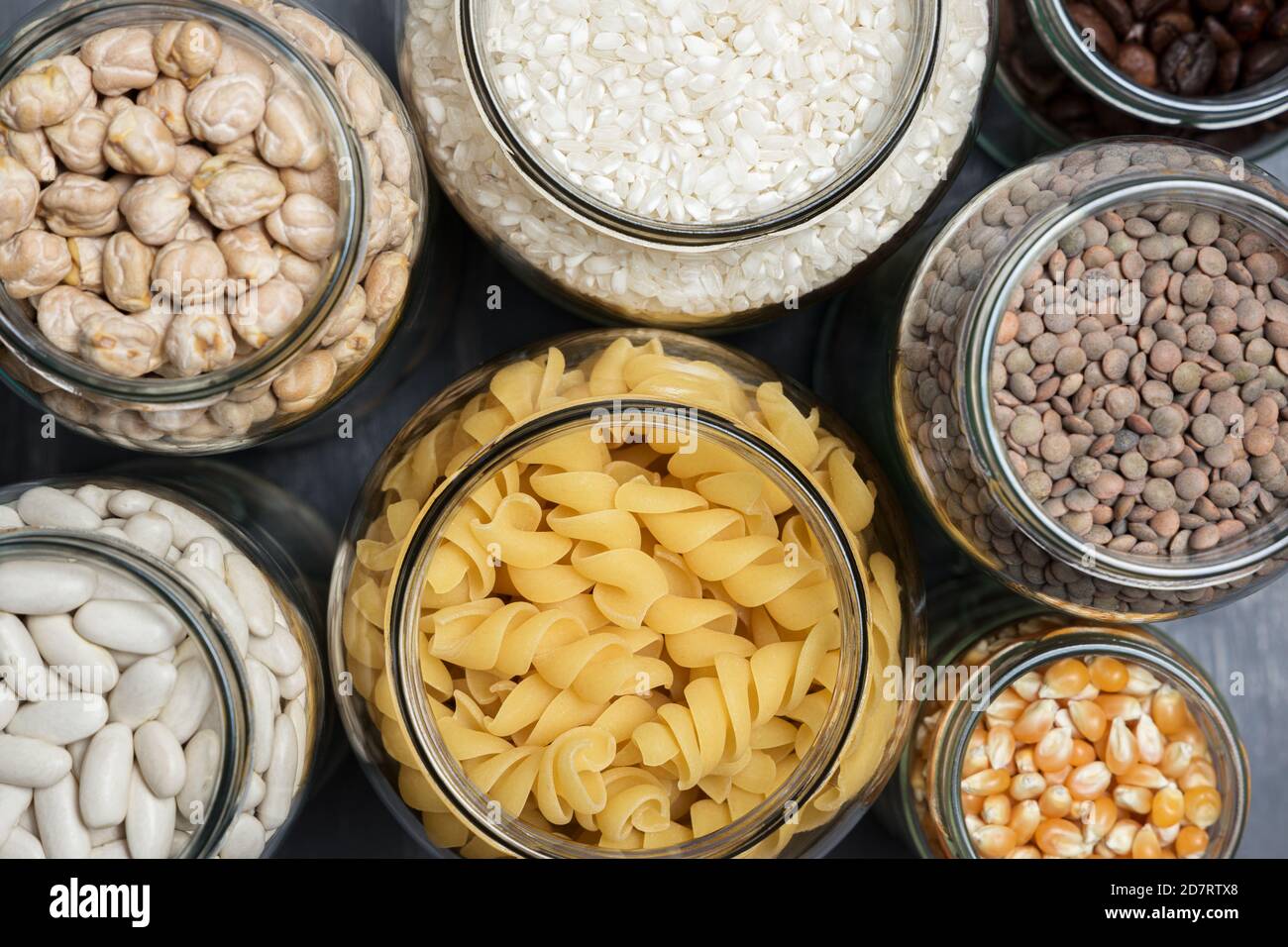 Set of glass jars with various ingredients placed on a table. Zero ...