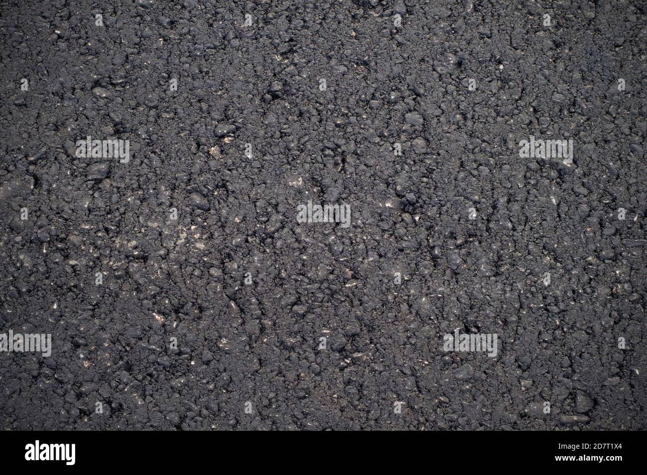 A dark grey asphalt pavement texture. Сlose-up of the repair of the ...
