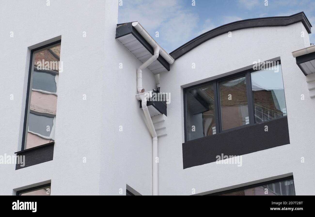 Frame house Rain gutter system. White gutter on the roof top of house ...