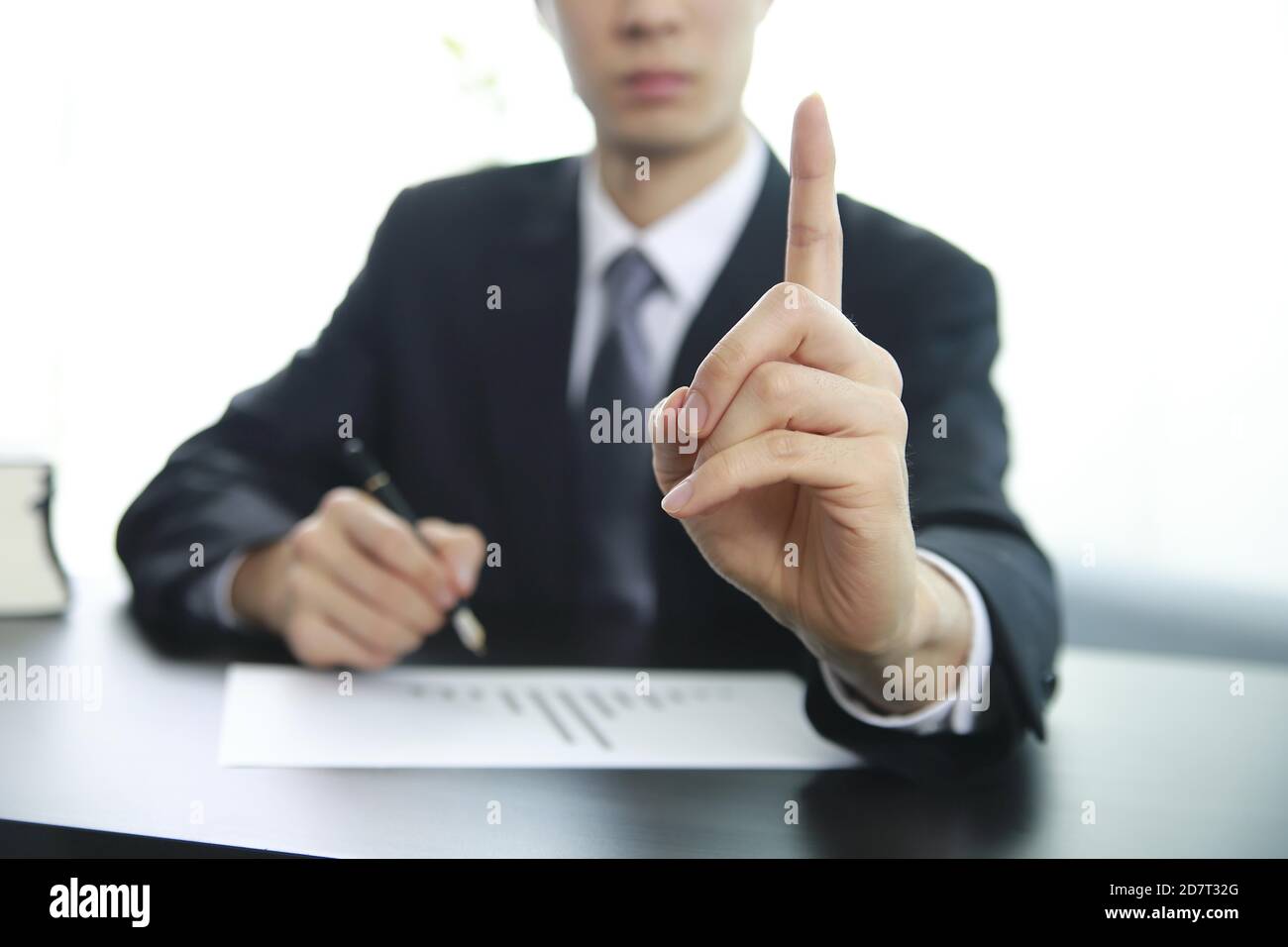 Lawyer showing number one finger at desk Stock Photo - Alamy