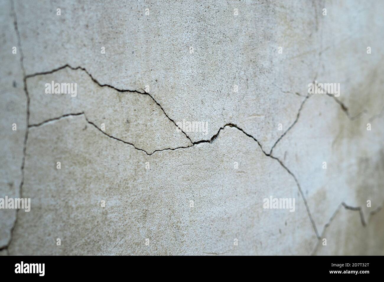 Old foundation and plaster wall with cracks. Building requiring repair ...