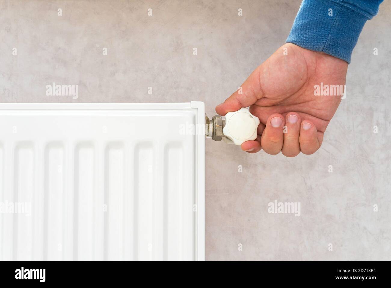 Hand adjusting the knob of heating radiator Stock Photo - Alamy