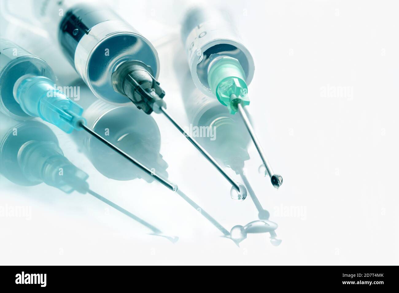 Three used syringes with medicinal solution, on light green background ...