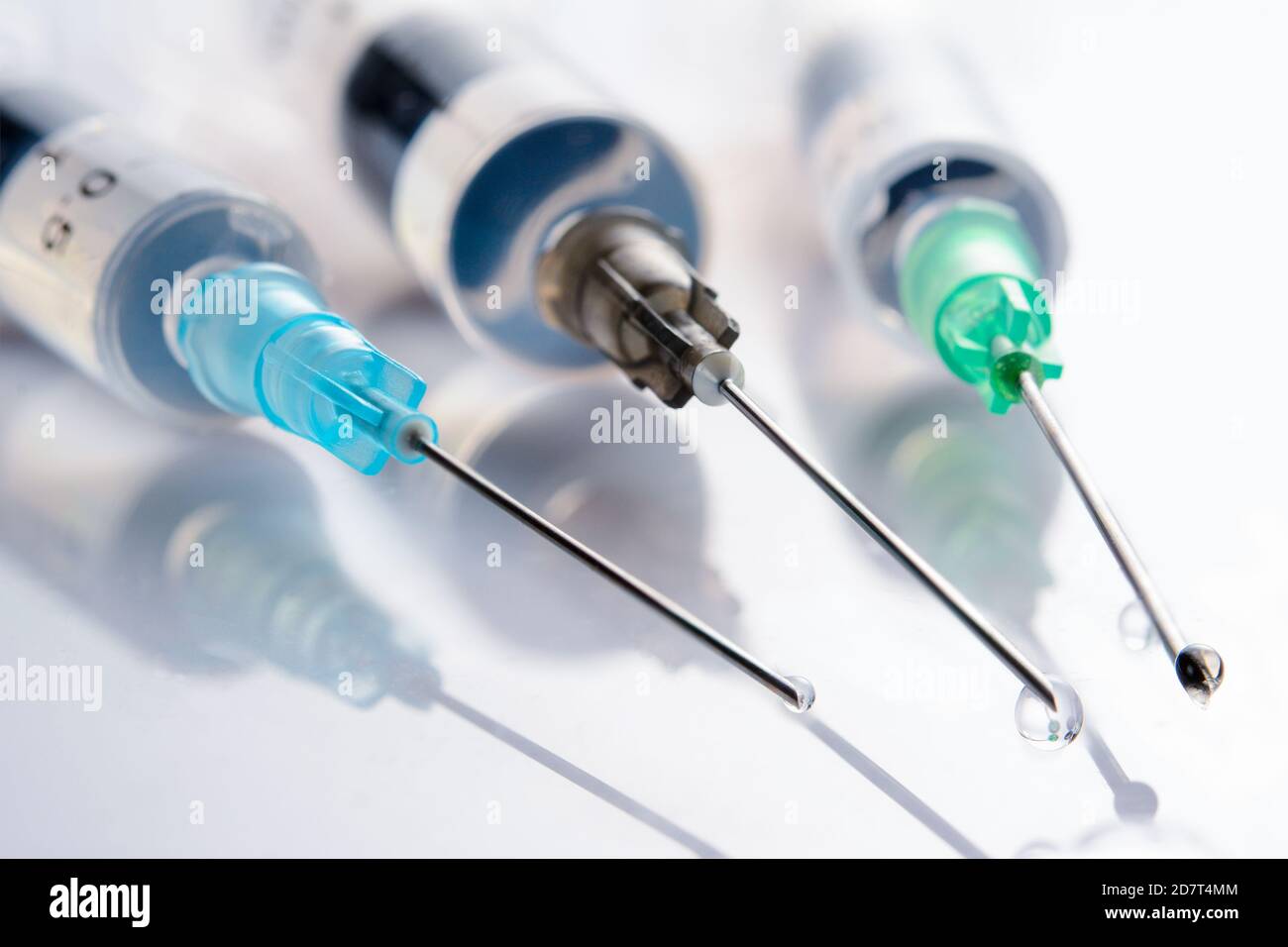 Three used syringes with medicinal solution, on light green background ...