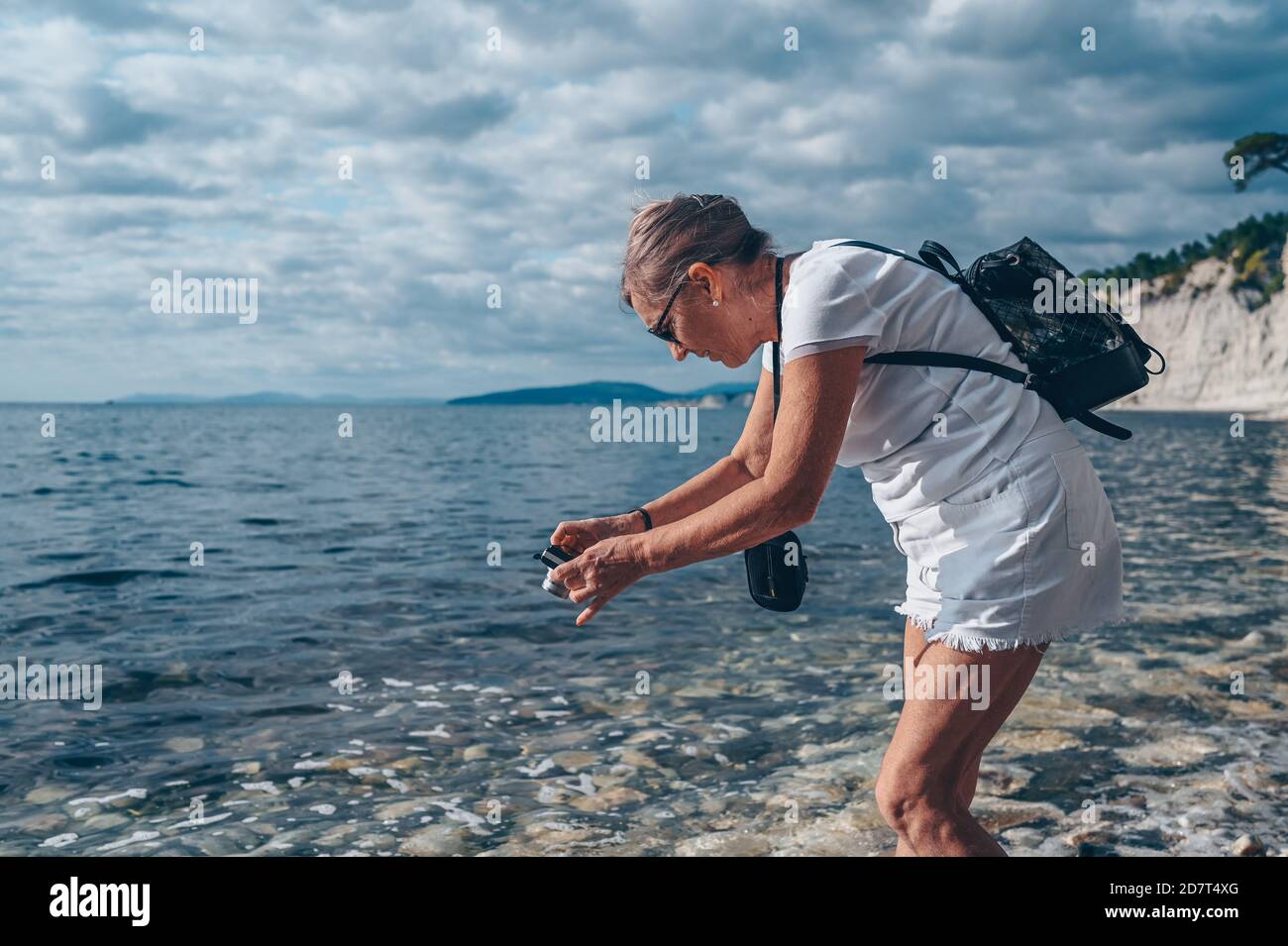 Elderly senior traveling backpacker mature woman tourist walking taking ...