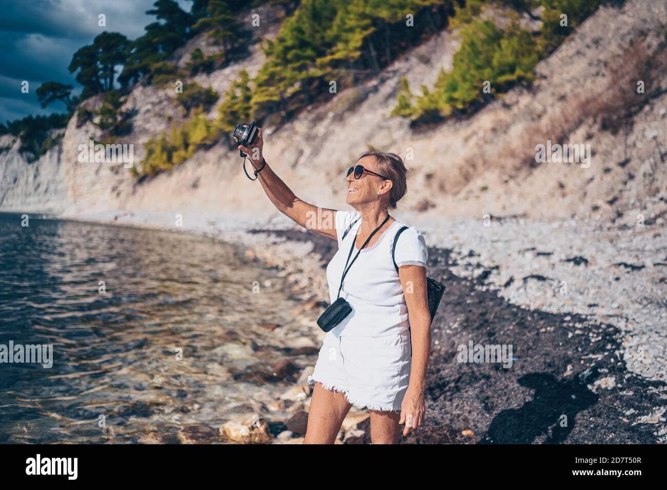 Elderly senior traveling backpacker mature woman tourist walking taking ...