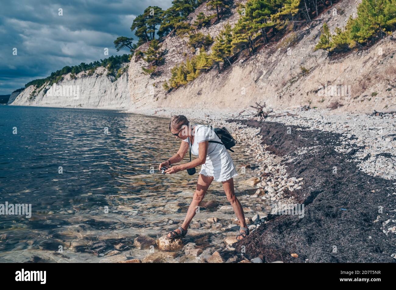 Elderly senior traveling backpacker mature woman tourist walking taking ...