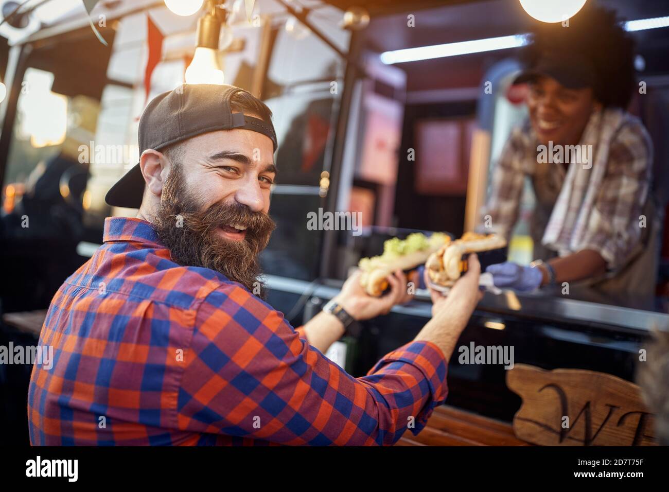 happy, satisfied caucasian beardy male customer taking sandwiches from ...
