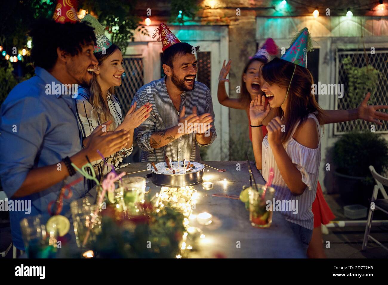 A group of happy friends congratulate the birthday to celebrant at a ...