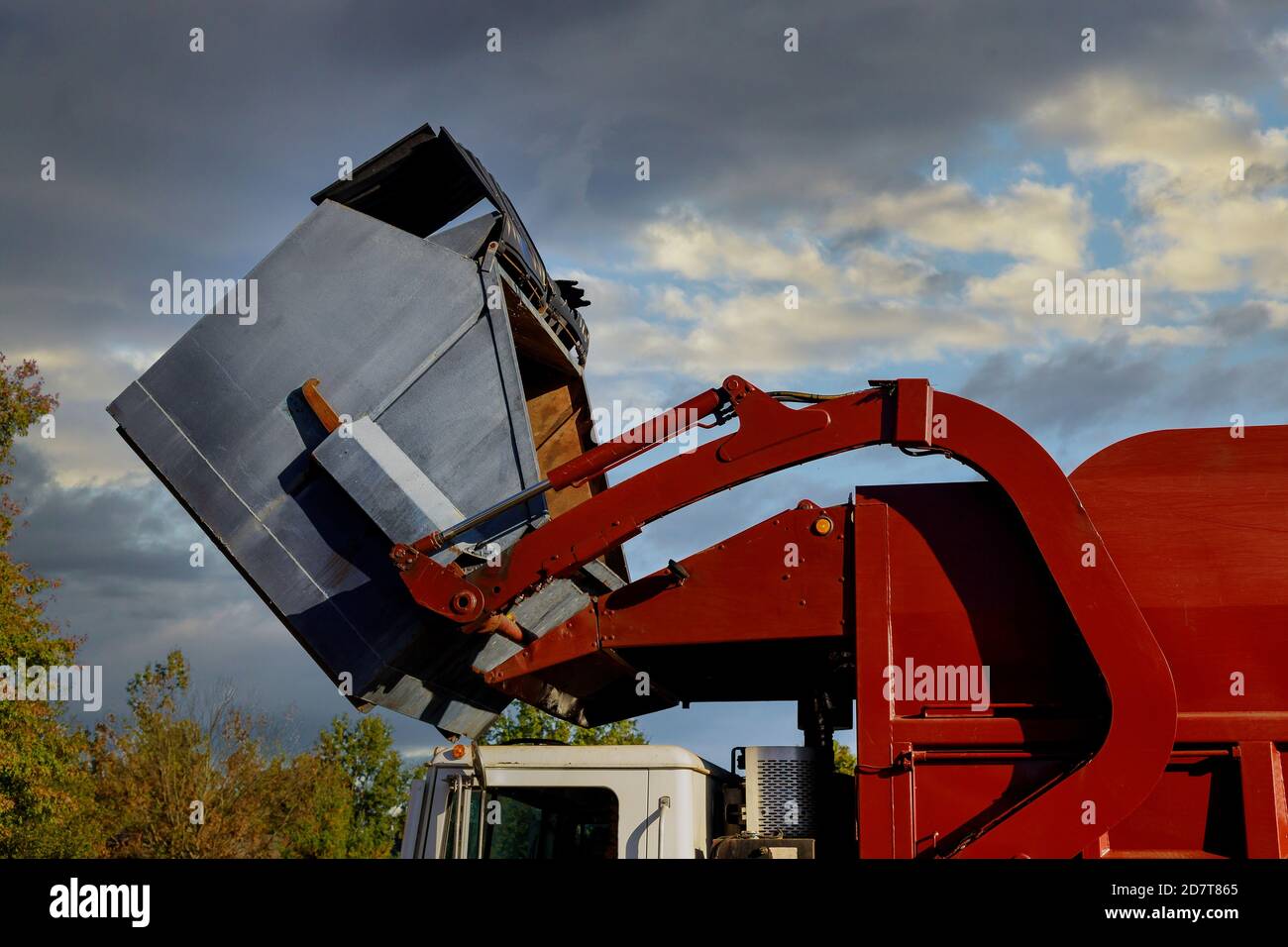 Lorry truck loading a skip waste management container near apartment ...