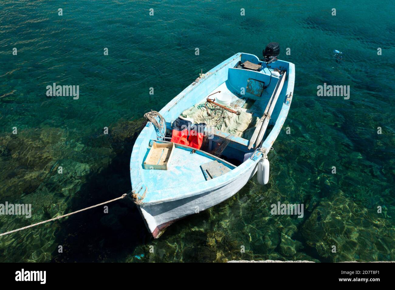 Little blue boat moored in cristal clear water in Cefalù, Sicily Stock ...