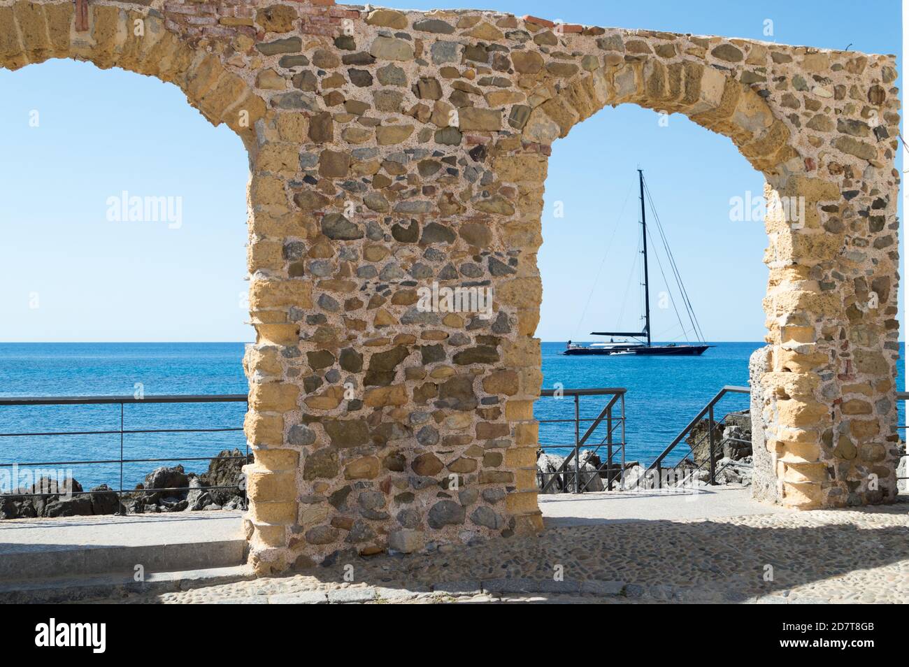 Pictoresque spot in the Cefalù main beach, two old stone arches frame a ...