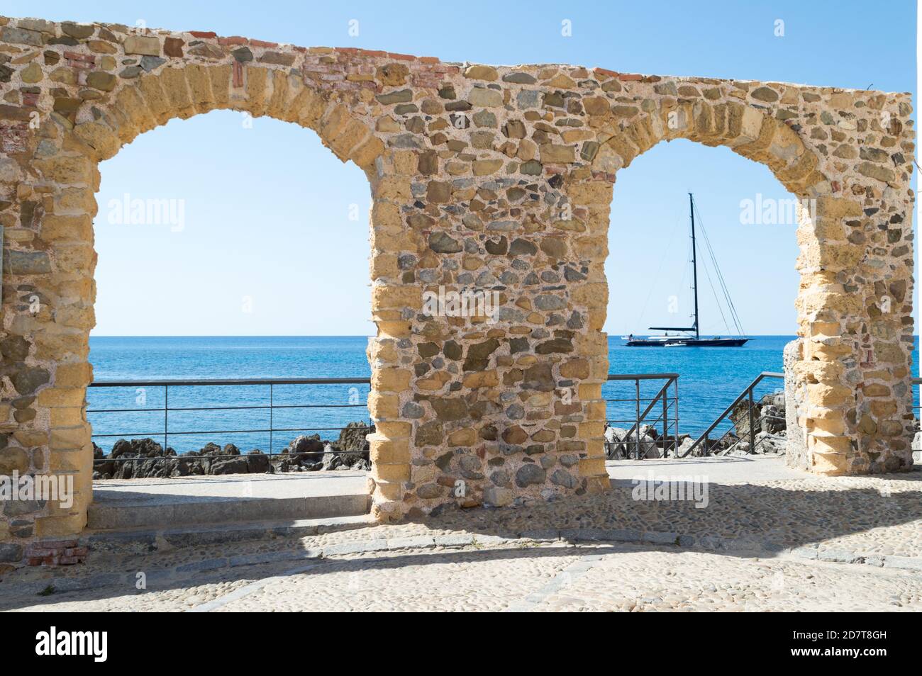 Pictoresque spot in the Cefalù main beach, two old stone arches frame a ...