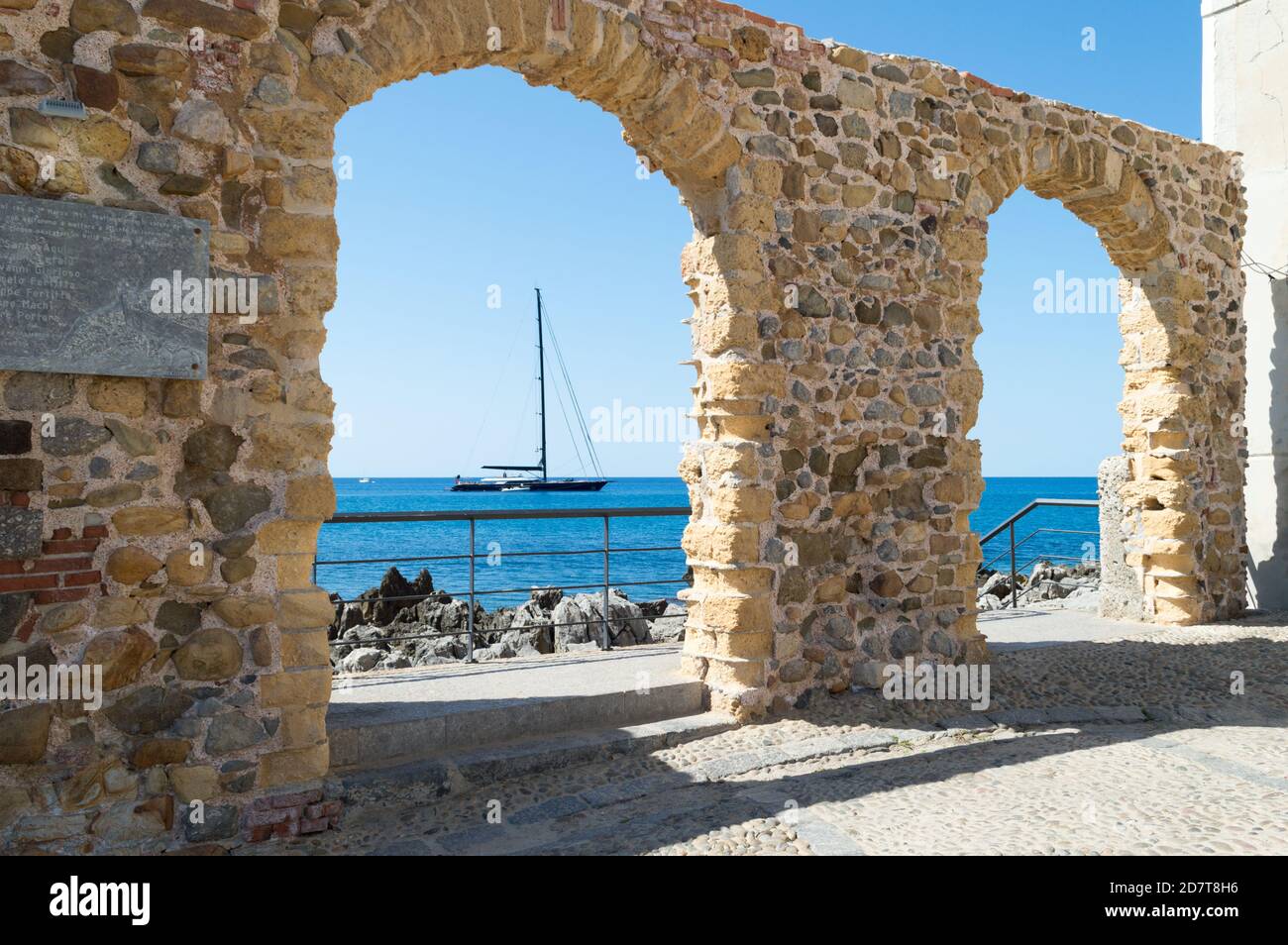 Pictoresque spot in the Cefalù main beach, two old stone arches frame a ...