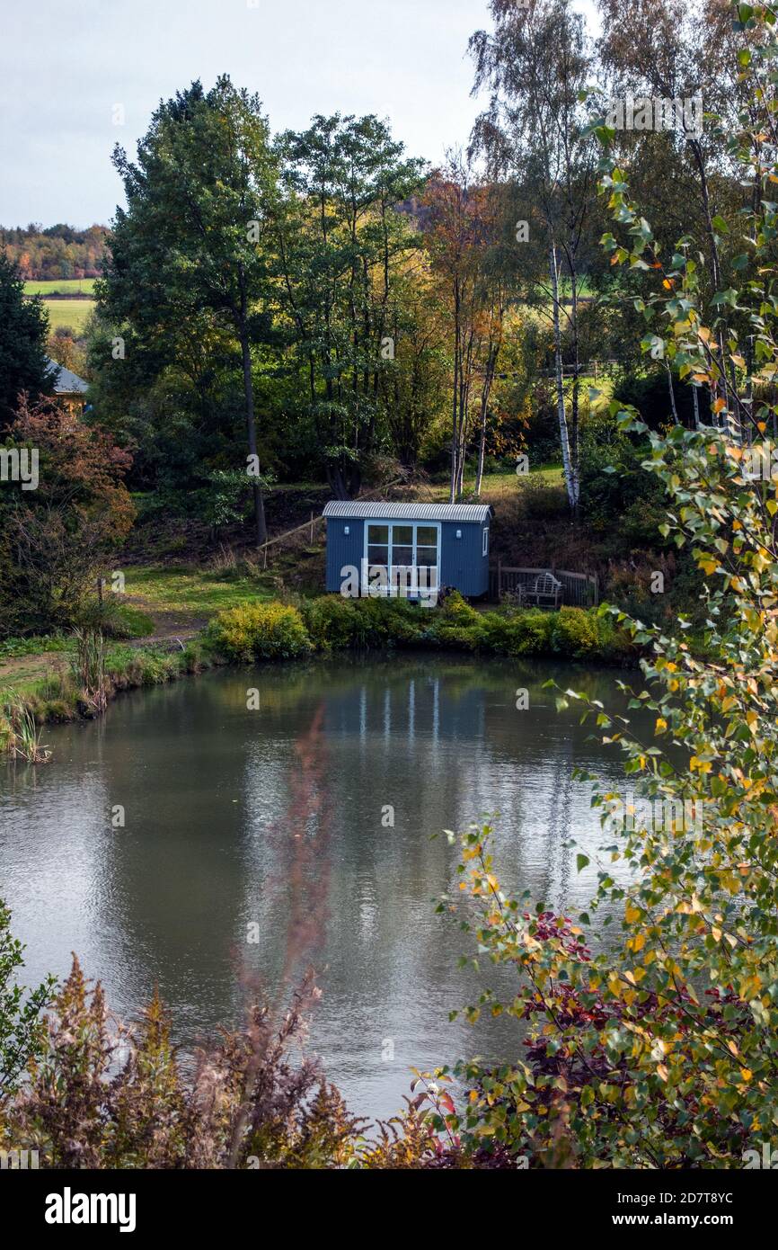 pretty private garden with lake and shepherds hut in autumn Stock Photo ...