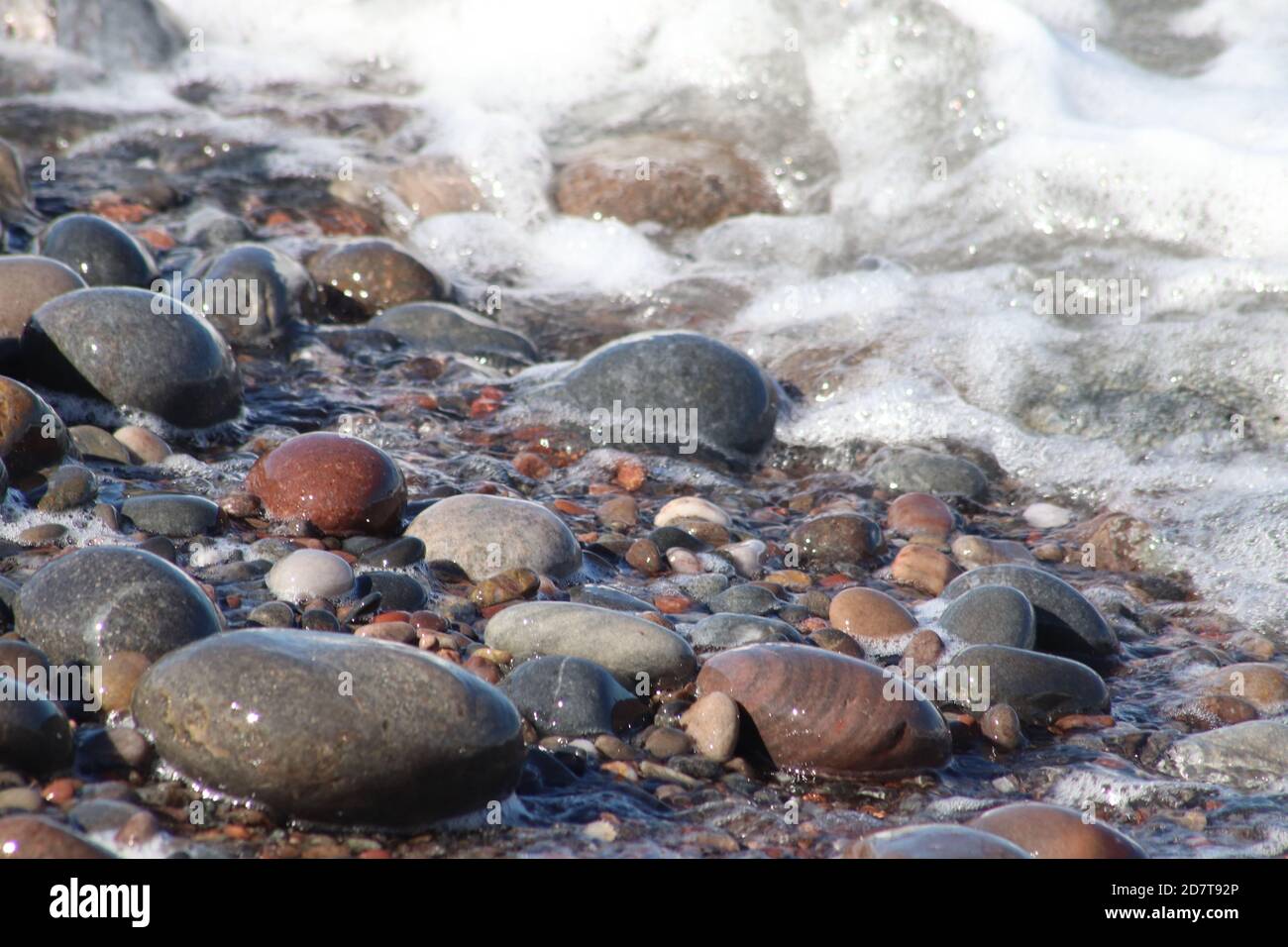 Waves on pebbles Stock Photo - Alamy