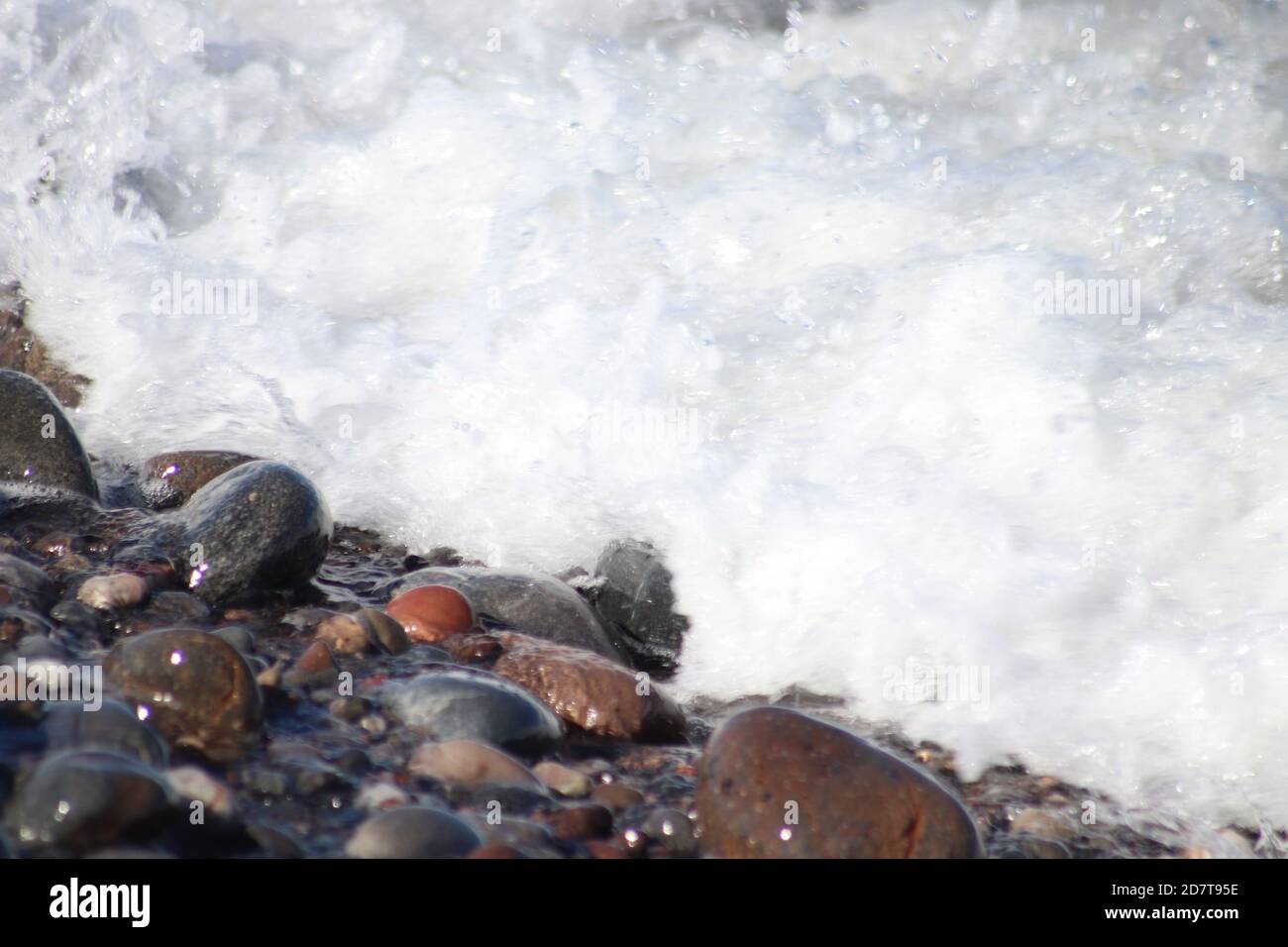 Waves on pebbles Stock Photo - Alamy