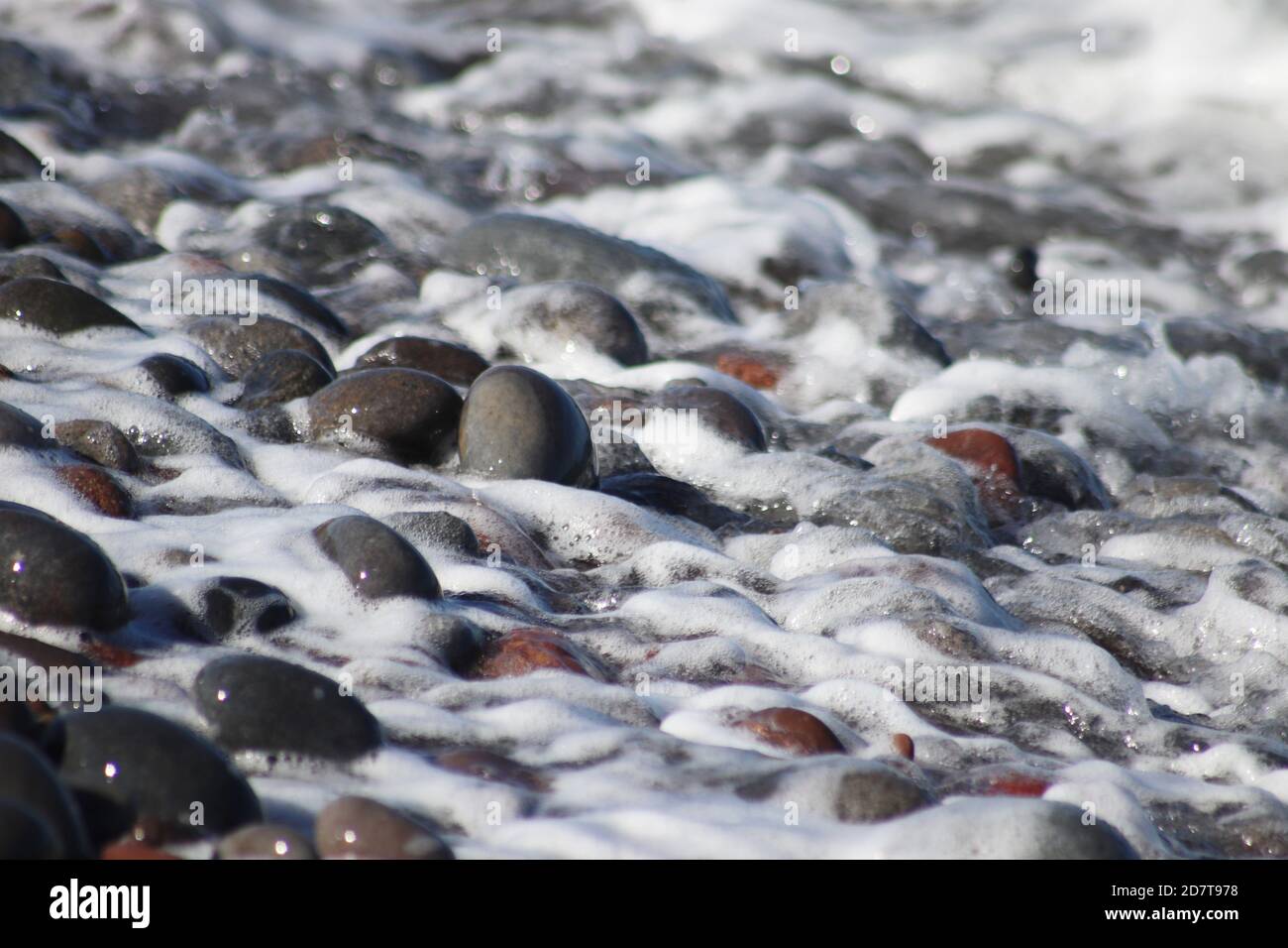 Waves on pebbles Stock Photo - Alamy