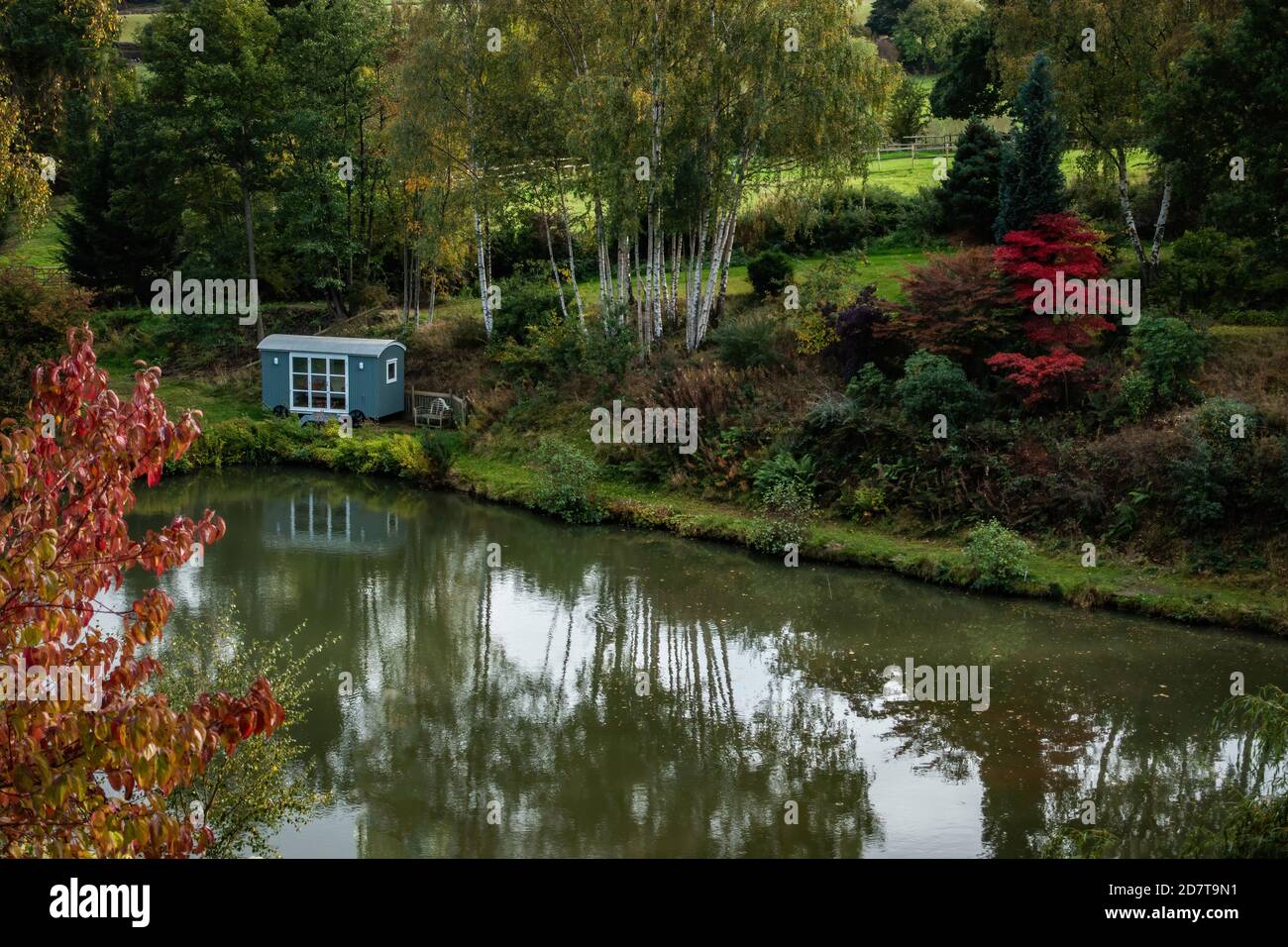 pretty private garden with lake and shepherds hut in autumn Stock Photo ...