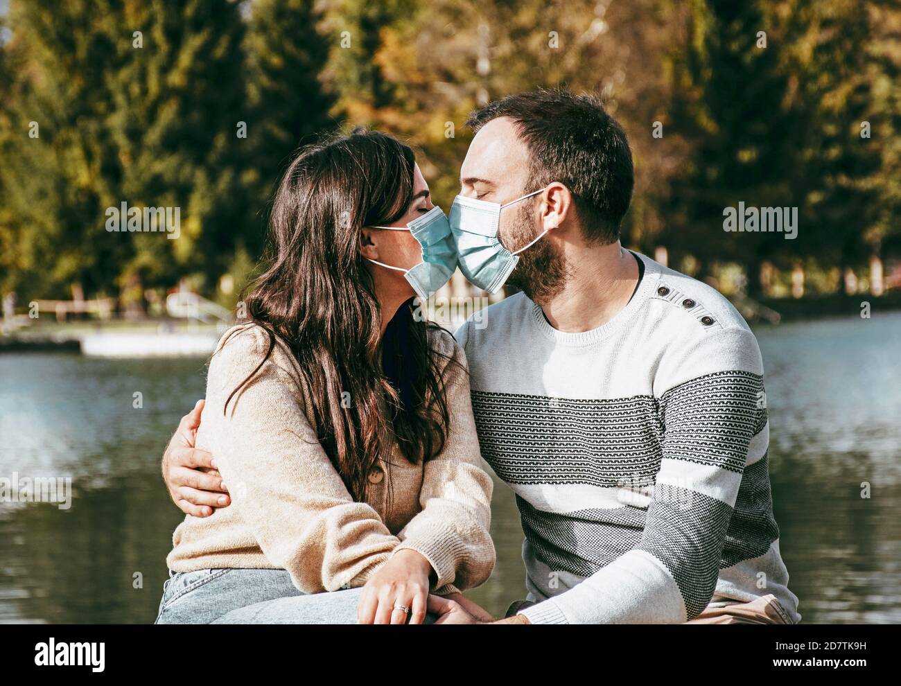 Cute couple kissing with their face masks on - new normal concept Stock ...