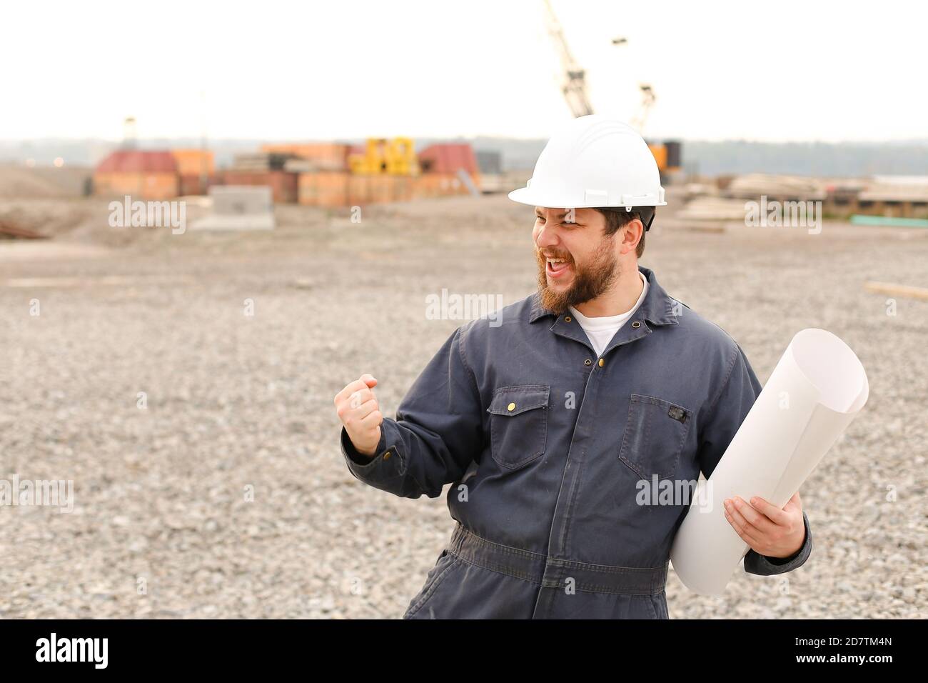 Happy building engineer holding blueprints papers on construction site ...